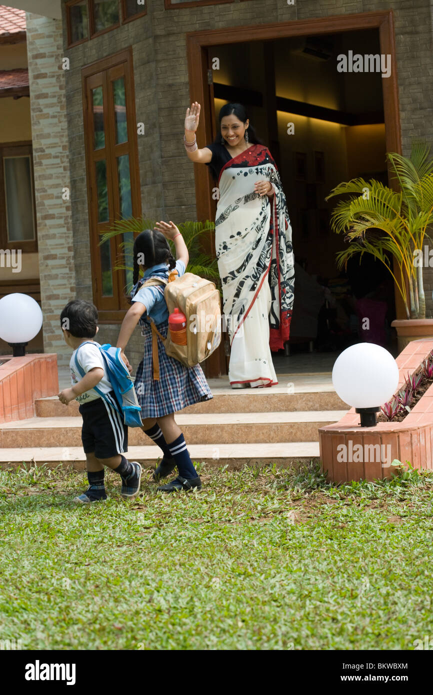 Mother waving off to daughter (8-9) and son (2-3 Stock Photo - Alamy