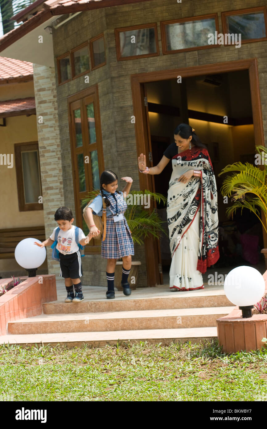 Mother waving off to daughter (8-9) and son (2-3 Stock Photo - Alamy
