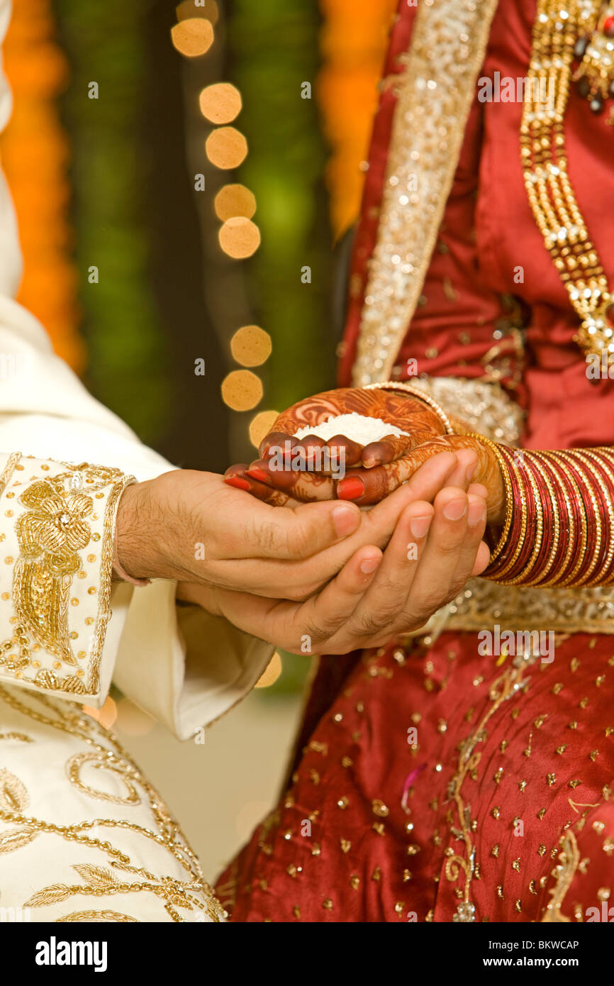 Indian couples hands together, bride with handful of rice grains Stock ...
