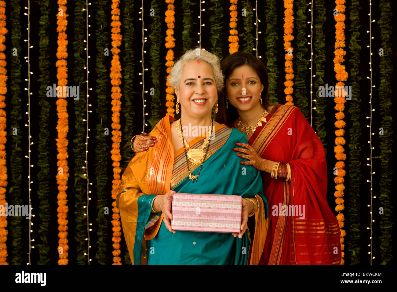 Mother and daughter wearing traditional dress, senior woman holding a ...