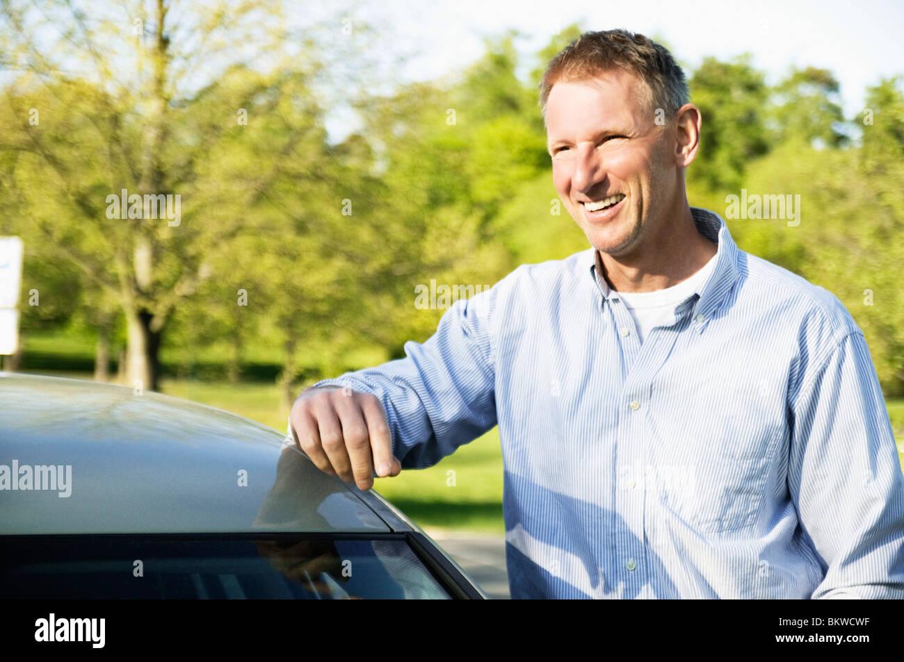 Man leaning against car Stock Photo - Alamy