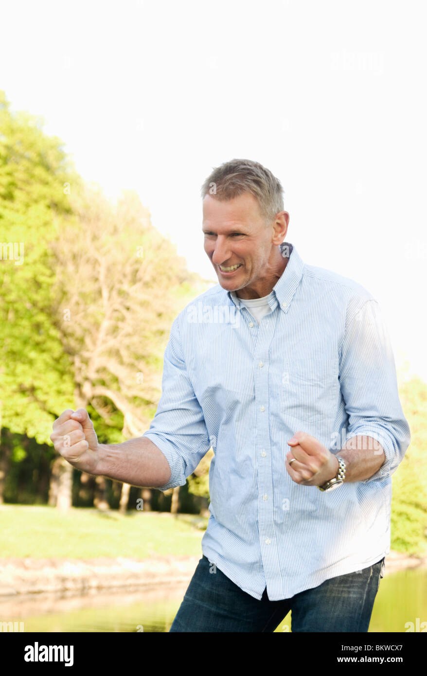 Happy man standing by pond Stock Photo - Alamy