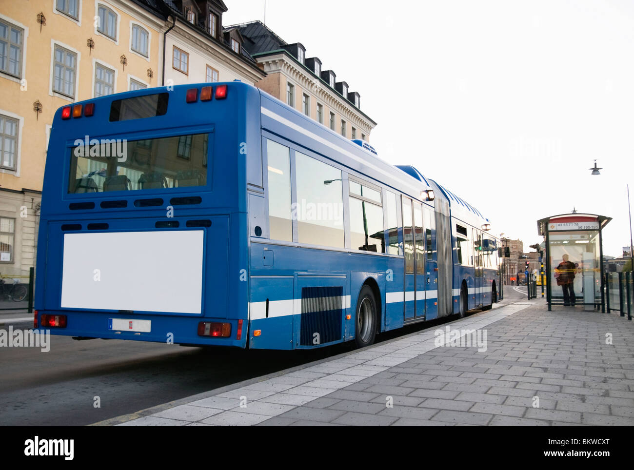 Town bus standing by busstop Stock Photo - Alamy