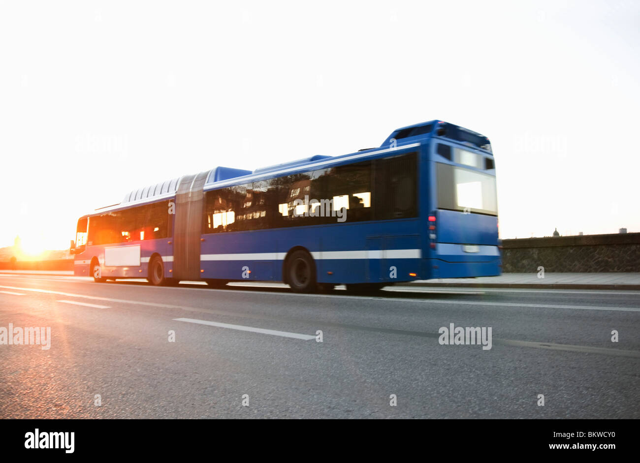 Bus driving in sunset Stock Photo - Alamy