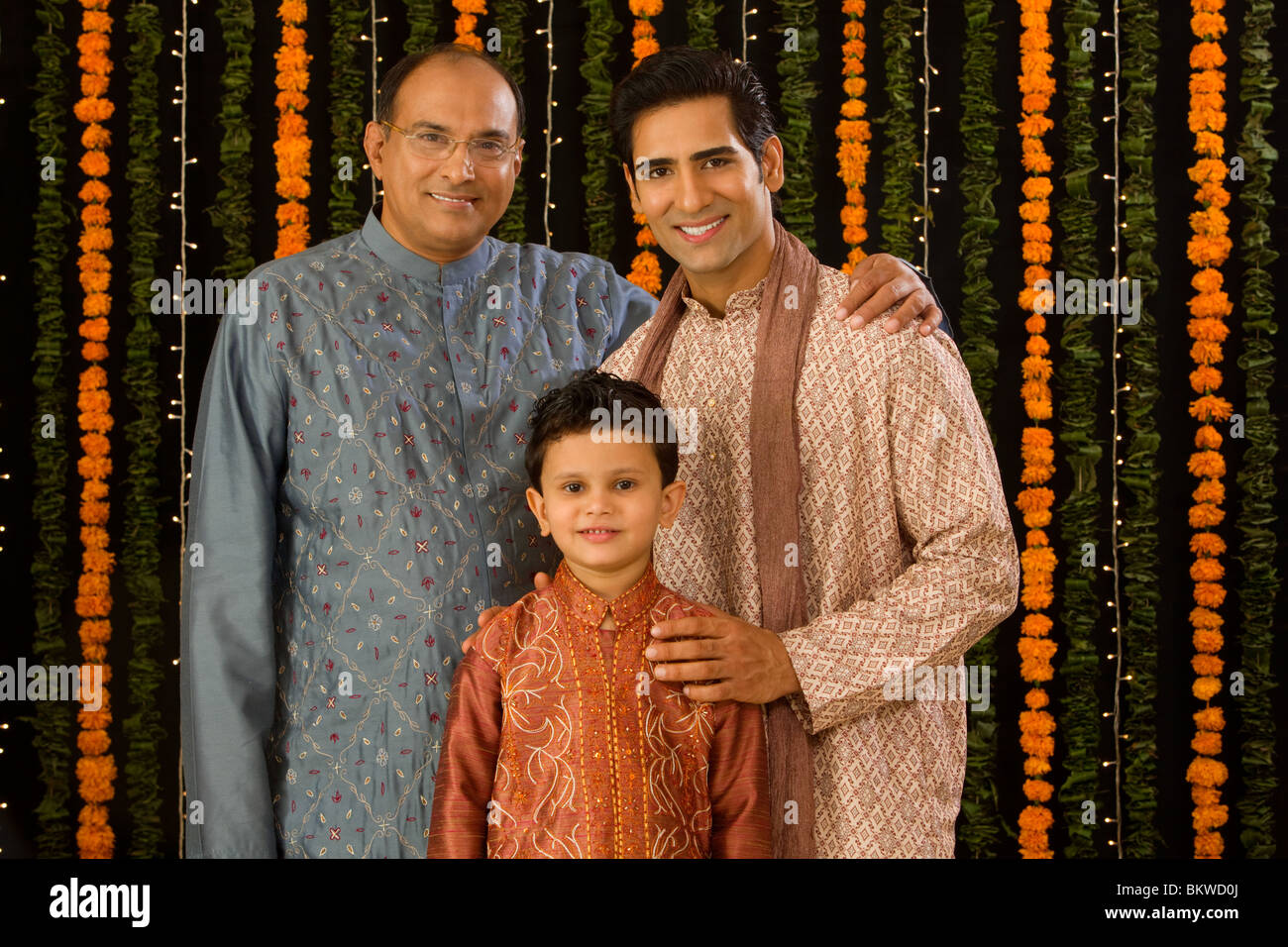 Three generation Indian men standing wearing traditional dress ...