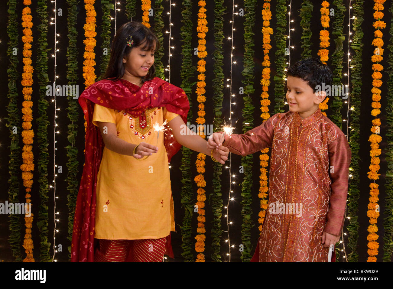 Two children holding firework, celebrating Diwali Stock Photo - Alamy