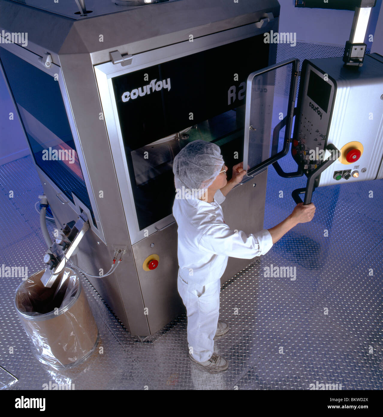 Worker operating equipment used to manufacture pharmaceutical products ...