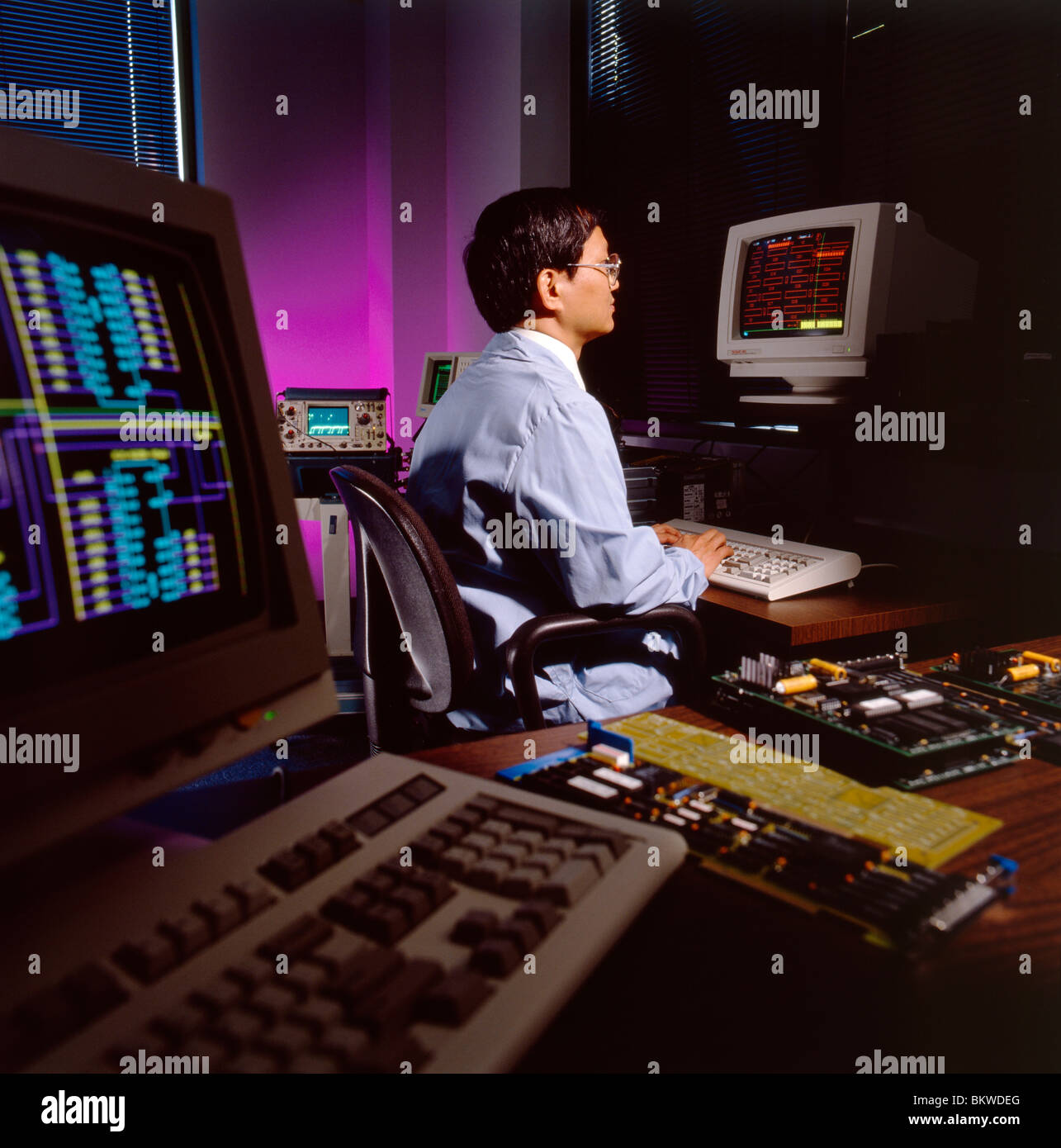 Asian male technician working with computers used to develop new ...
