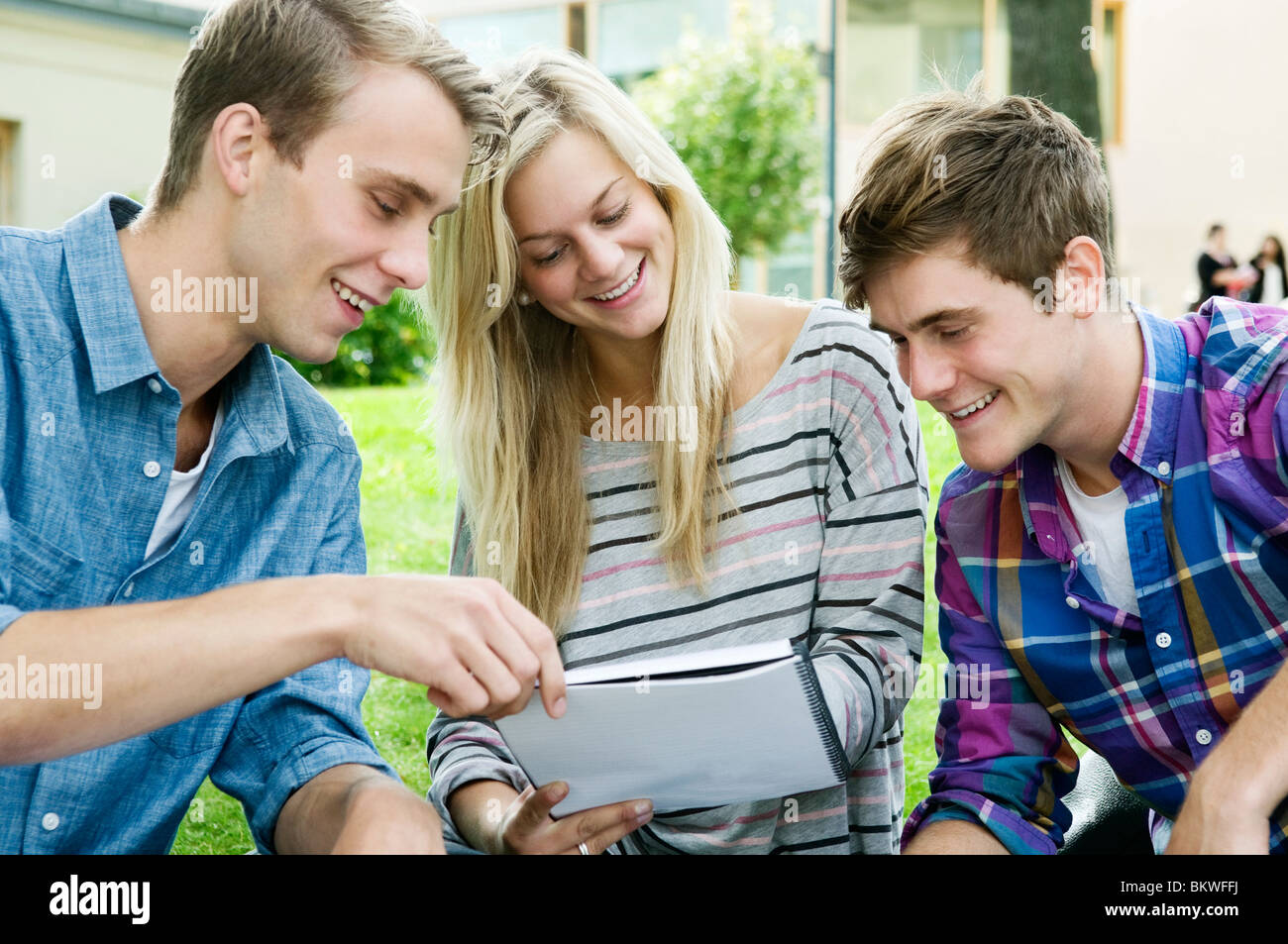 Three students sitting outdoors Stock Photo - Alamy