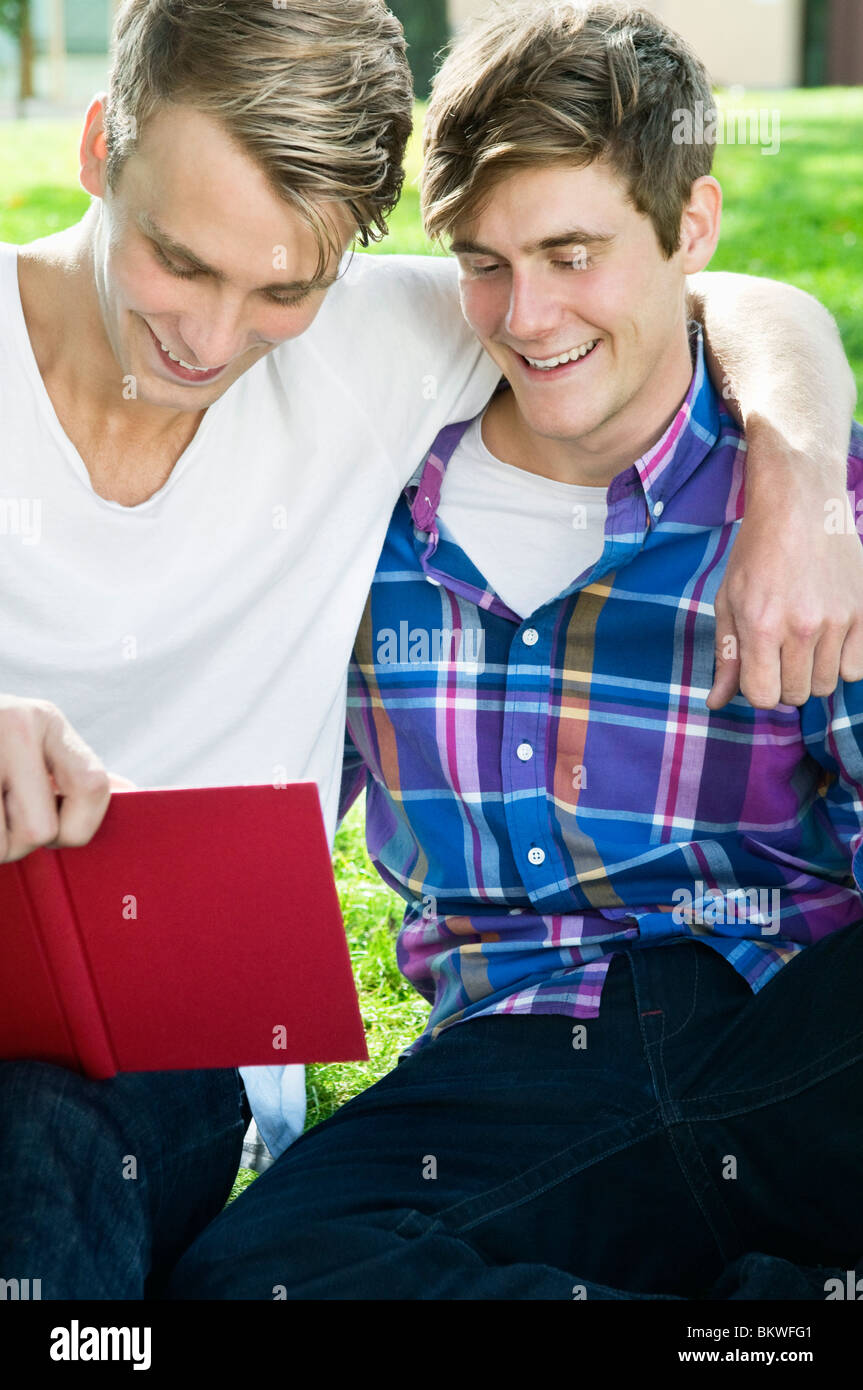 Two guys reading a book Stock Photo - Alamy