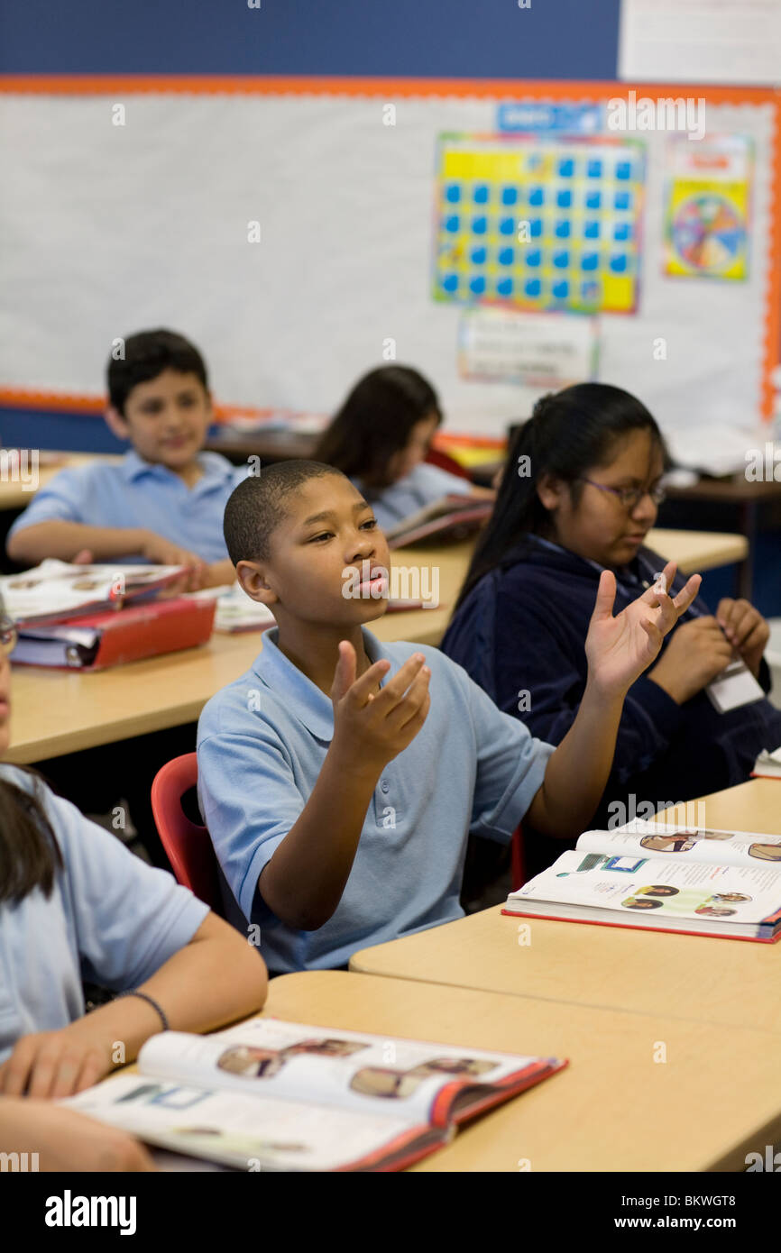 African-American middle school boy gestures as he as in his classroom ...