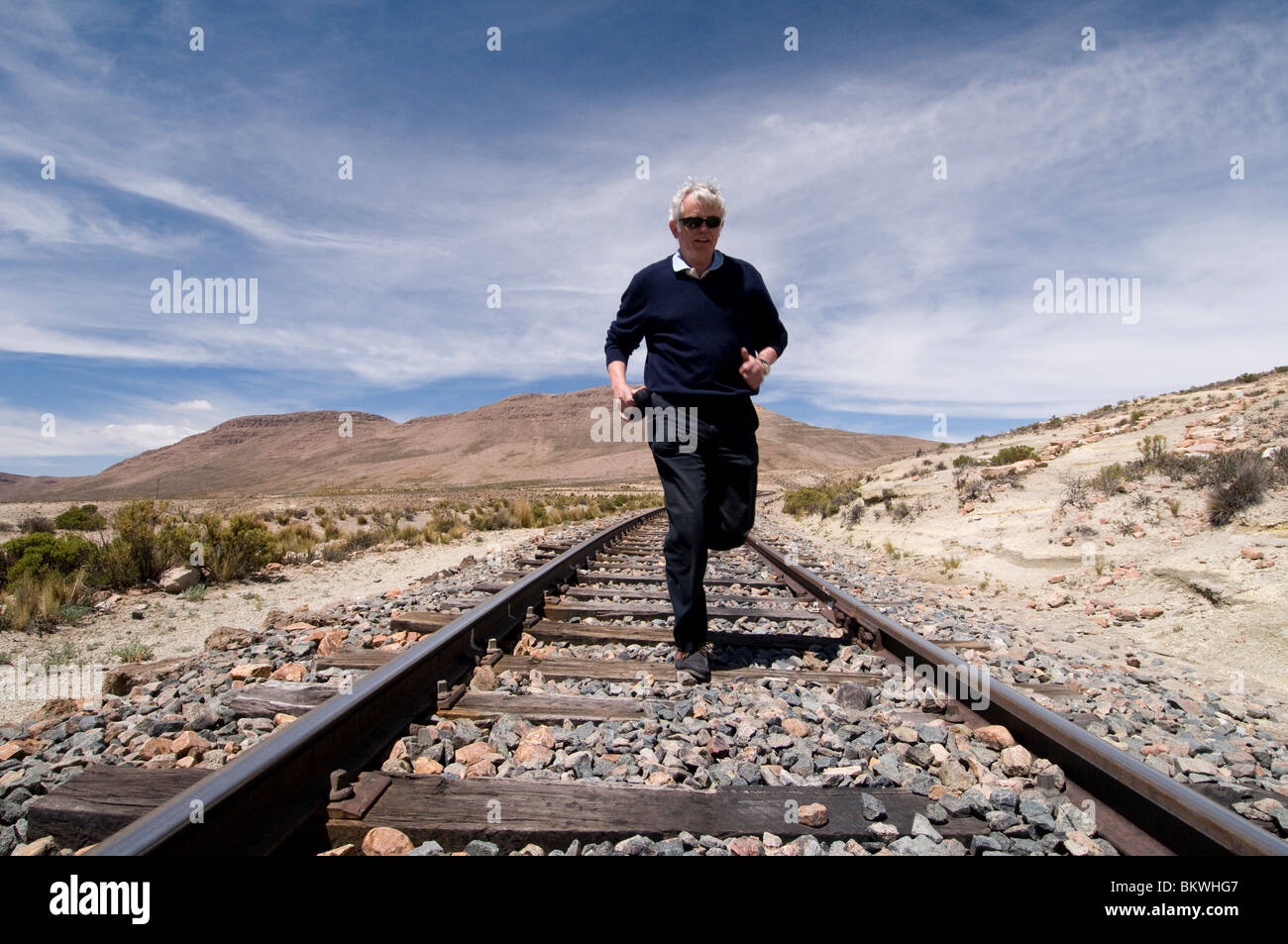 man running down railway track Stock Photo - Alamy