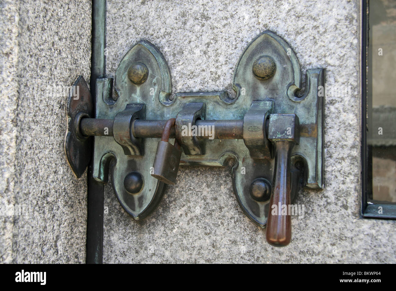 A grand bolt and padlock sealing a granite doorway Stock Photo - Alamy