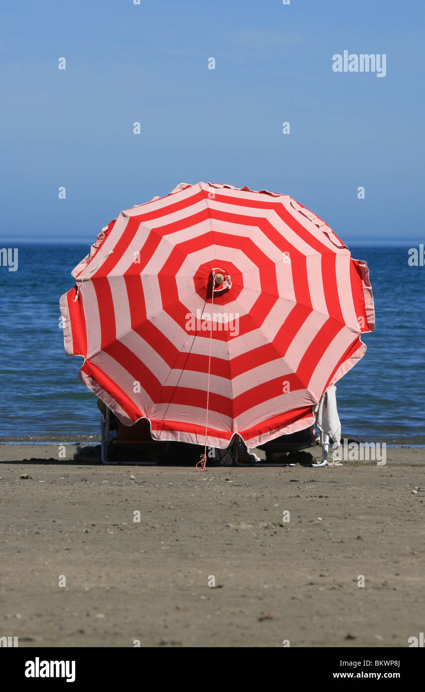 A single red and white beach umbrella, Puerto Madryn, Argentina Stock ...