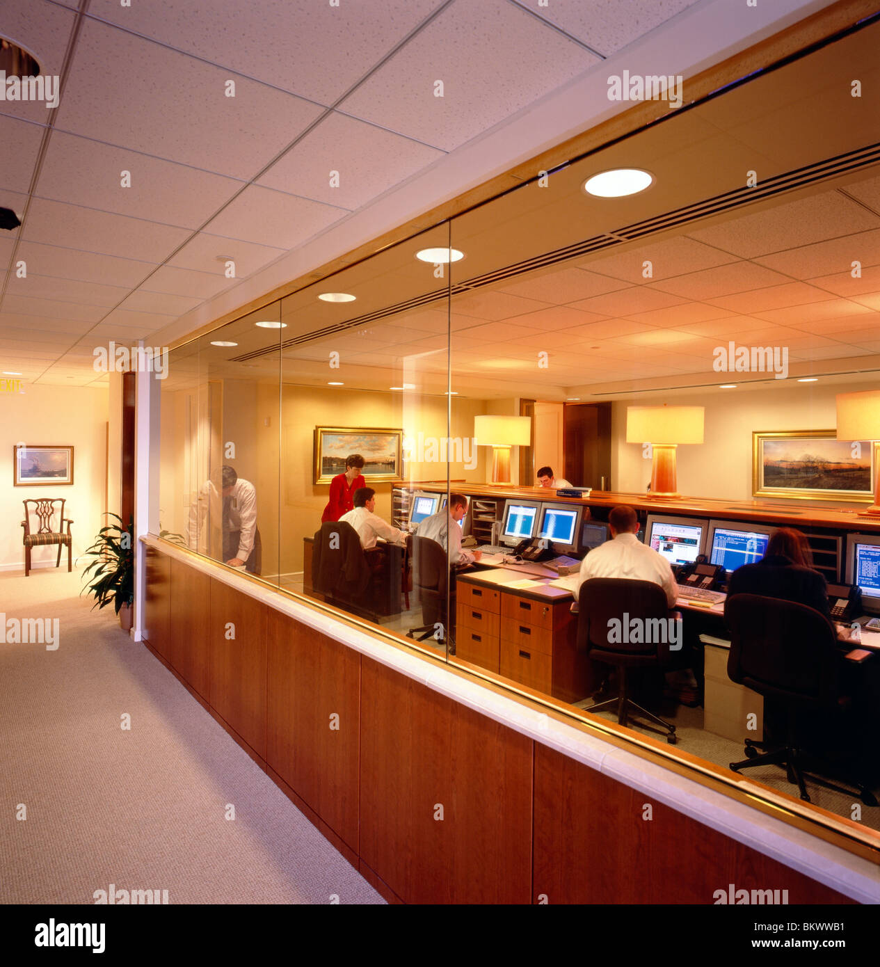 Corporate workers at desks using computers & telephones in the offices ...