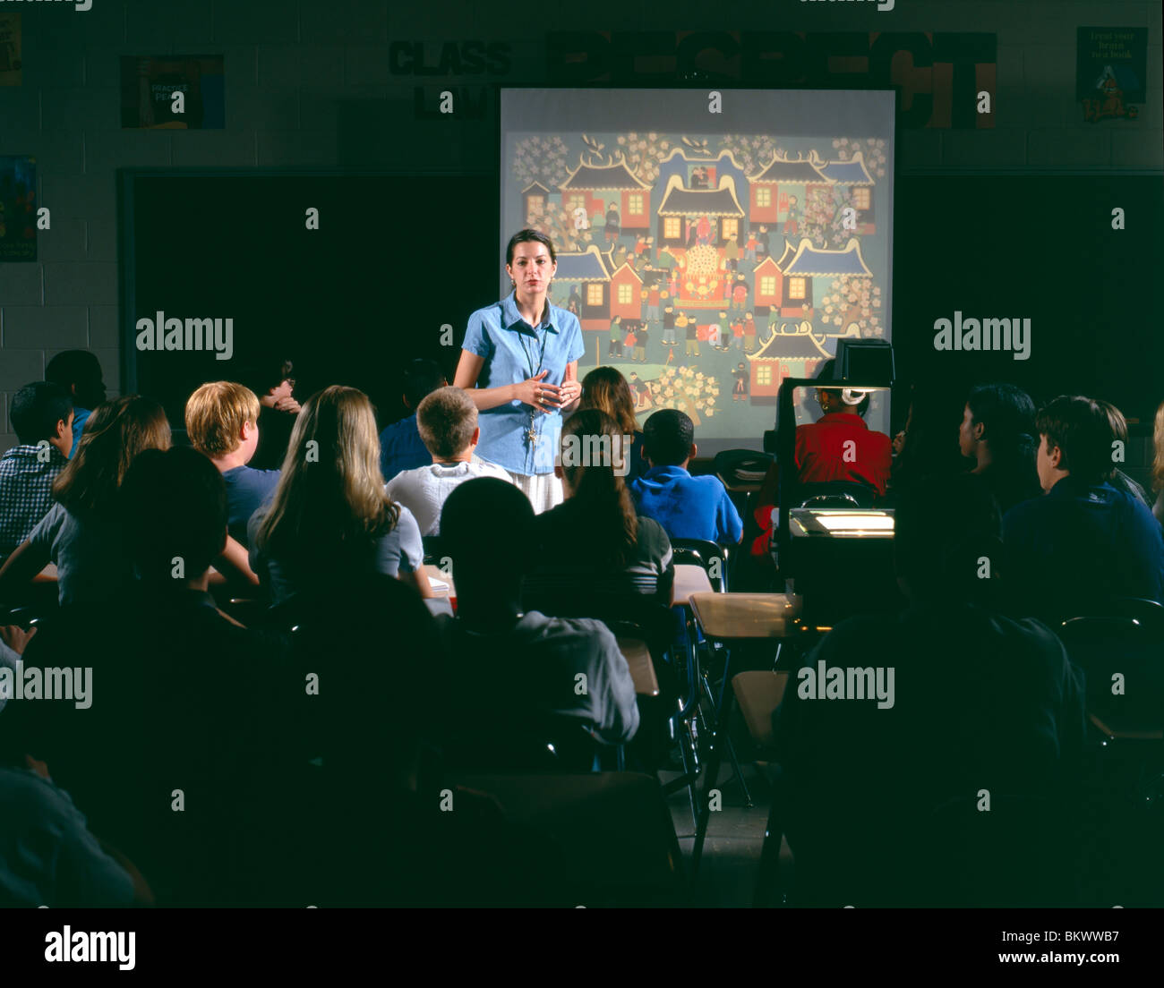 Female middle school teacher projecting an overhead transparency to a ...