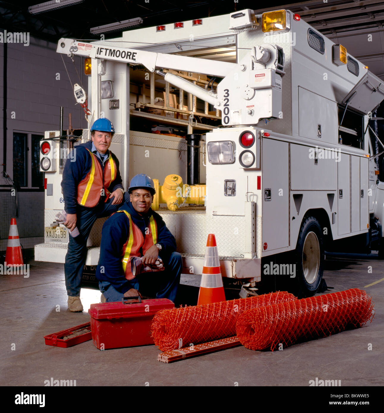 Employees of water company pose for a photograph with their utility ...
