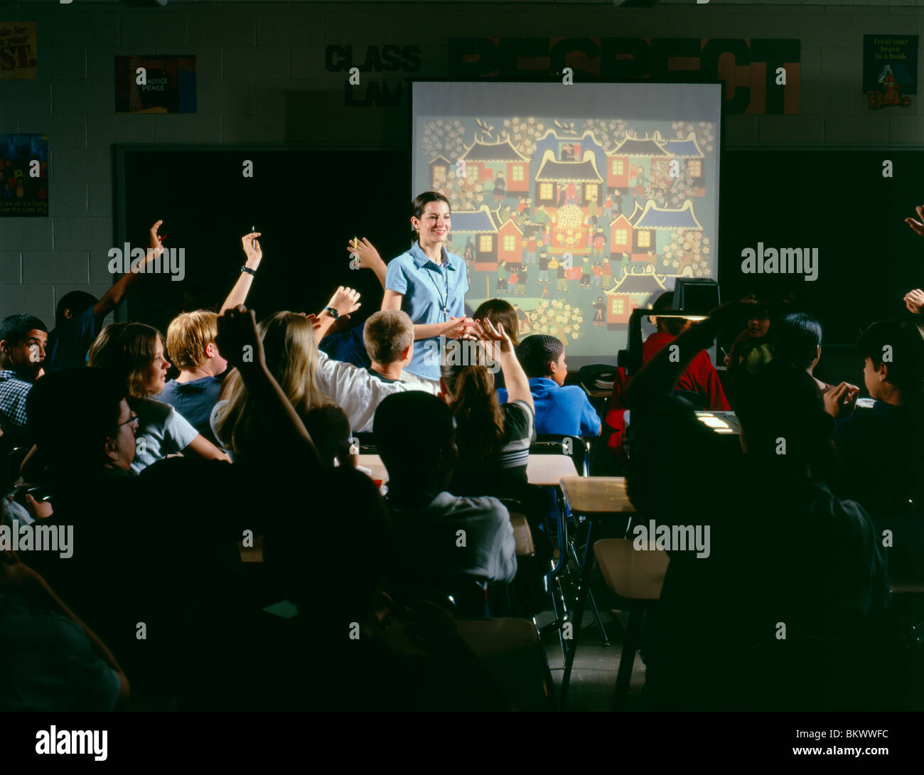 Female middle school teacher projecting an overhead transparency to a ...