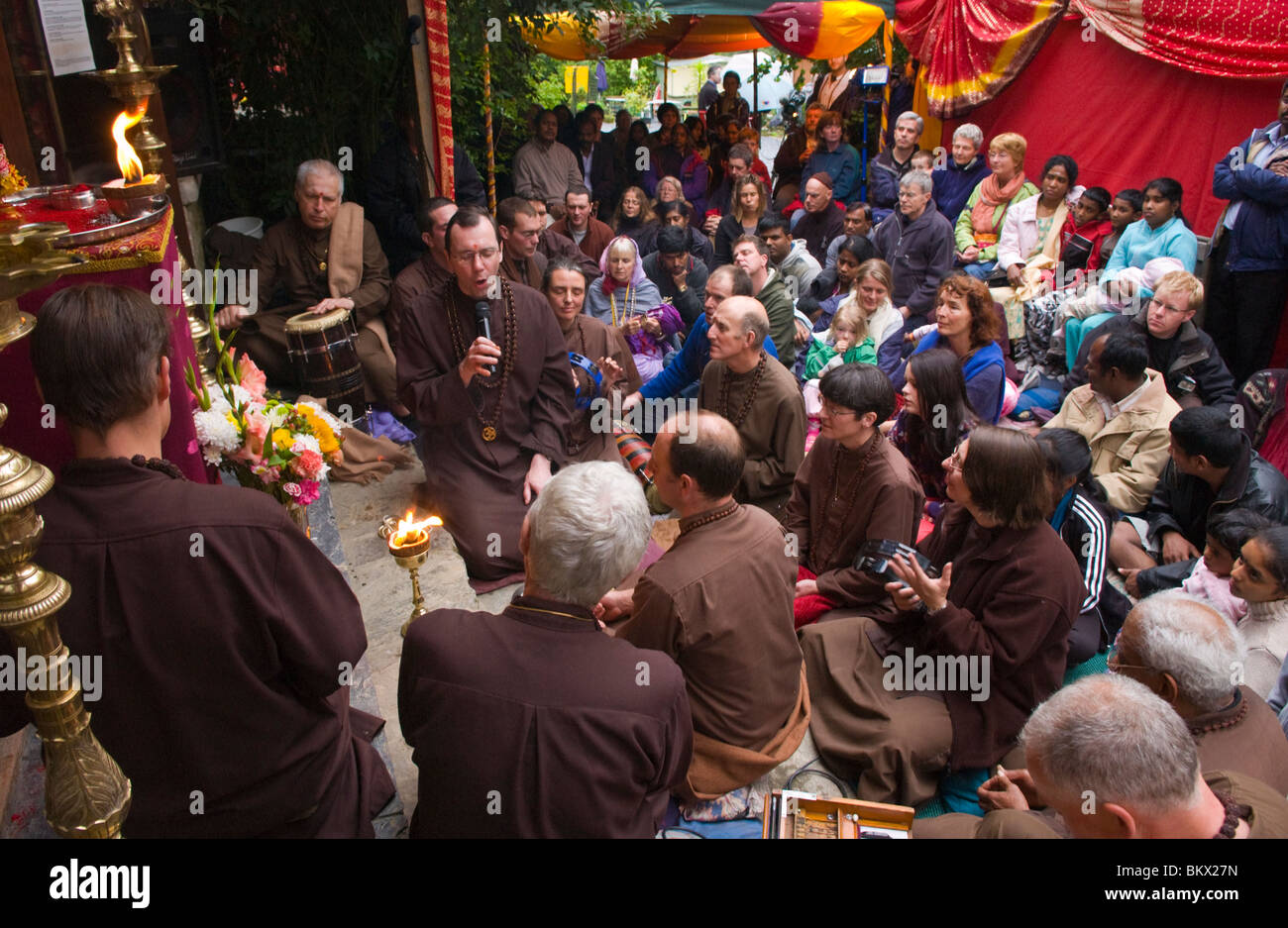 Monks and visitors chanting and praying outside the stall of sacred ...