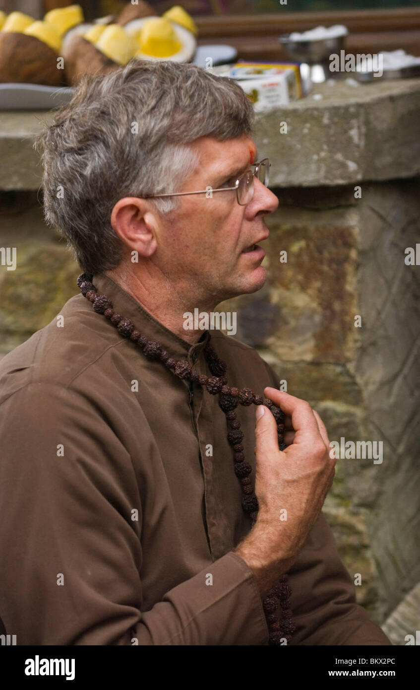 Hindu monks chanting and praying outside the stall of sacred bull ...