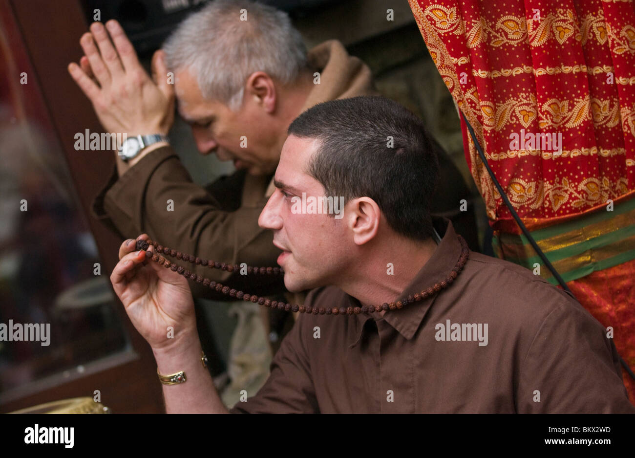 Hindu monks chanting and praying outside the stall of sacred bull ...