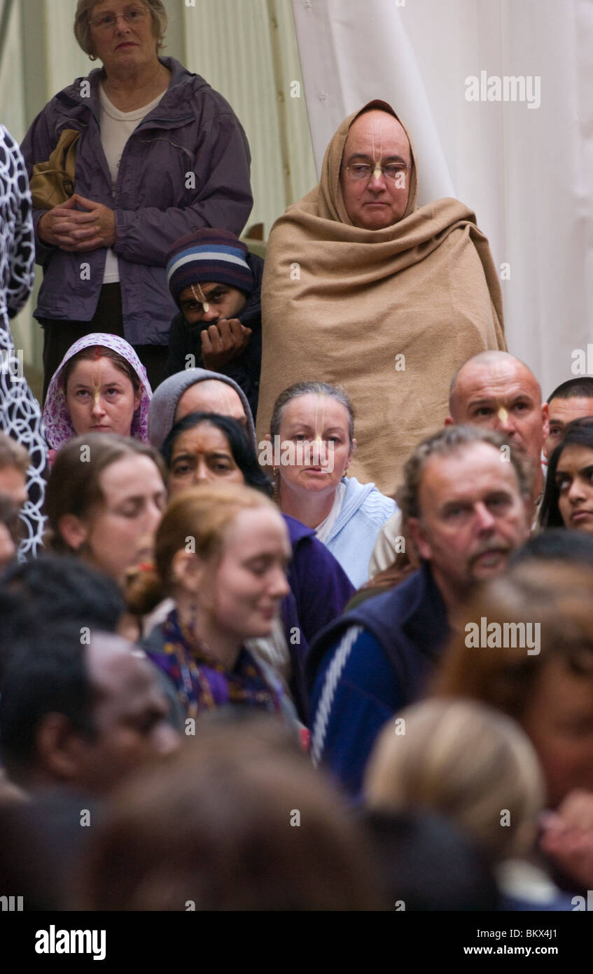 Monks and visitors chanting and praying outside the stall of sacred ...
