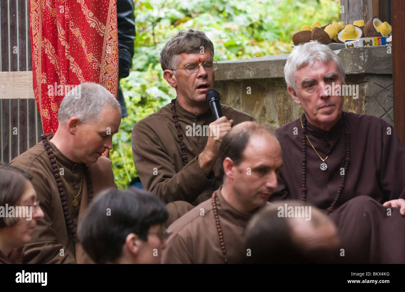 Hindu monks chanting and praying outside the stall of sacred bull ...