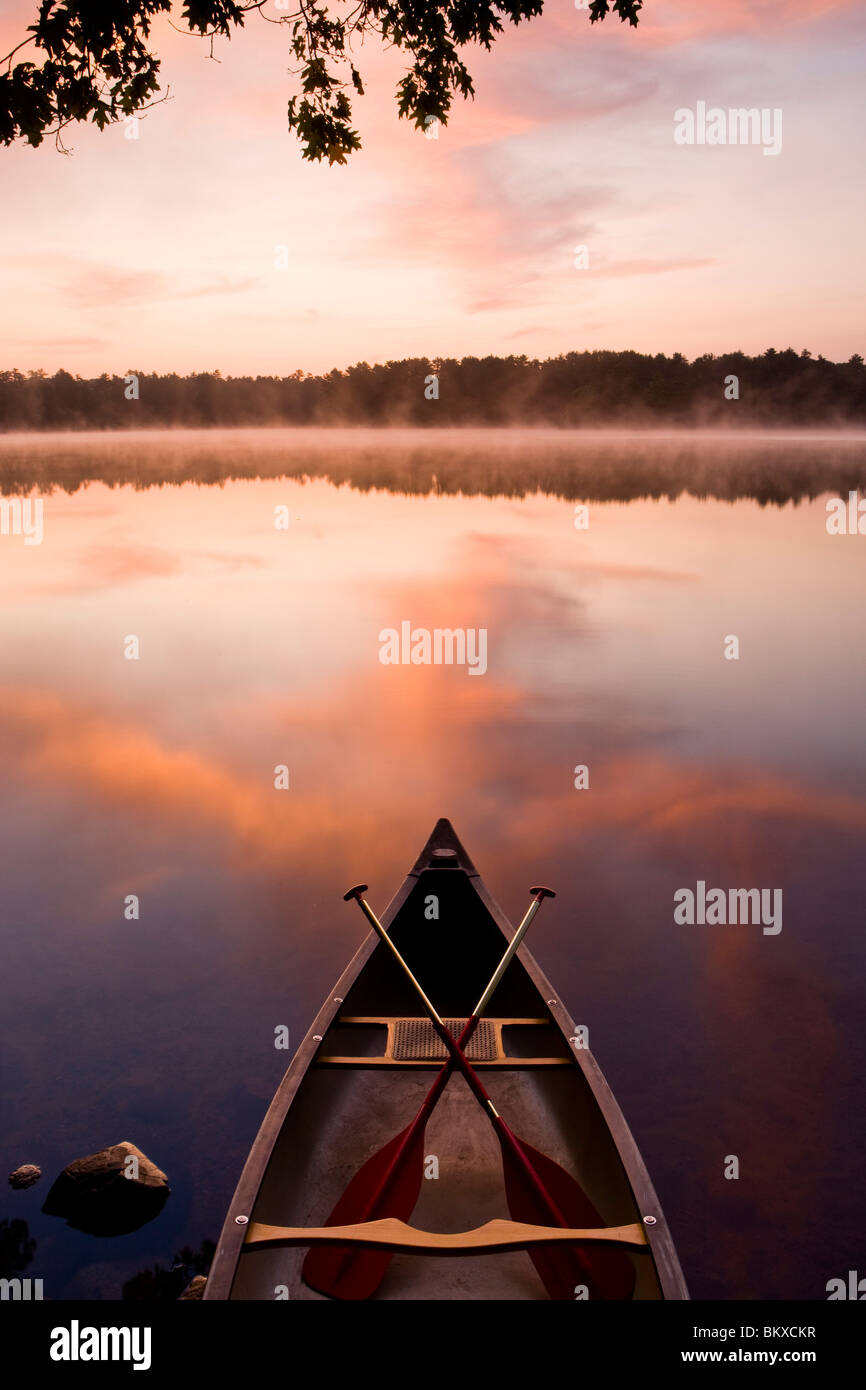 A canoe rests on the shore of Pawtuckaway Lake at dawn as seen from ...