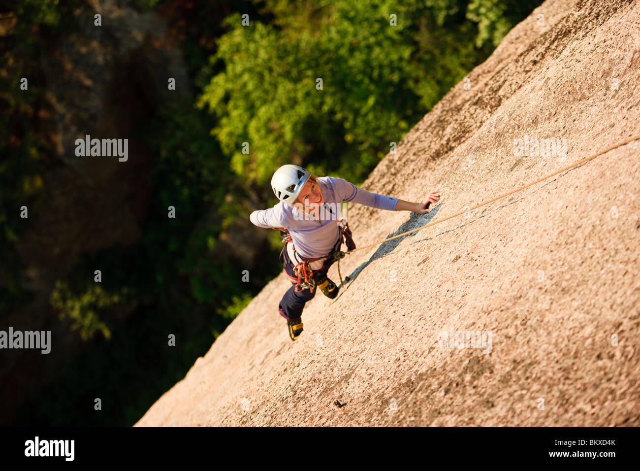 A woman rock climbing near the top of Cathedral Ledge. Echo Lake State ...