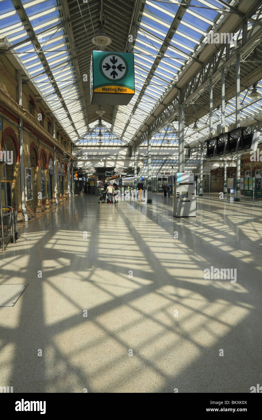 Bright sunshine illuminates the concourse at Eastbourne Railway Station ...