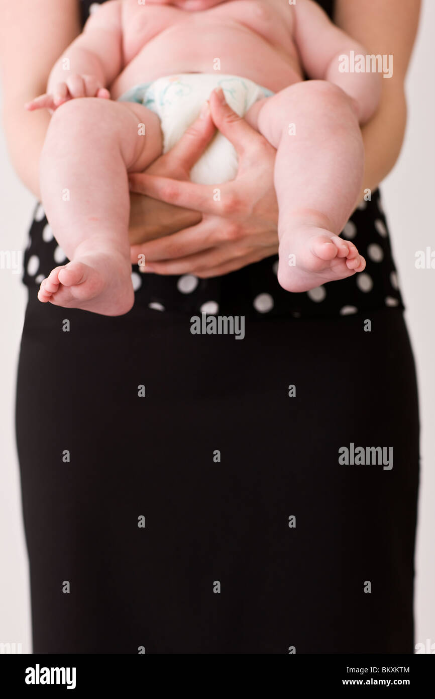 Woman holding baby against her body - headless Stock Photo - Alamy