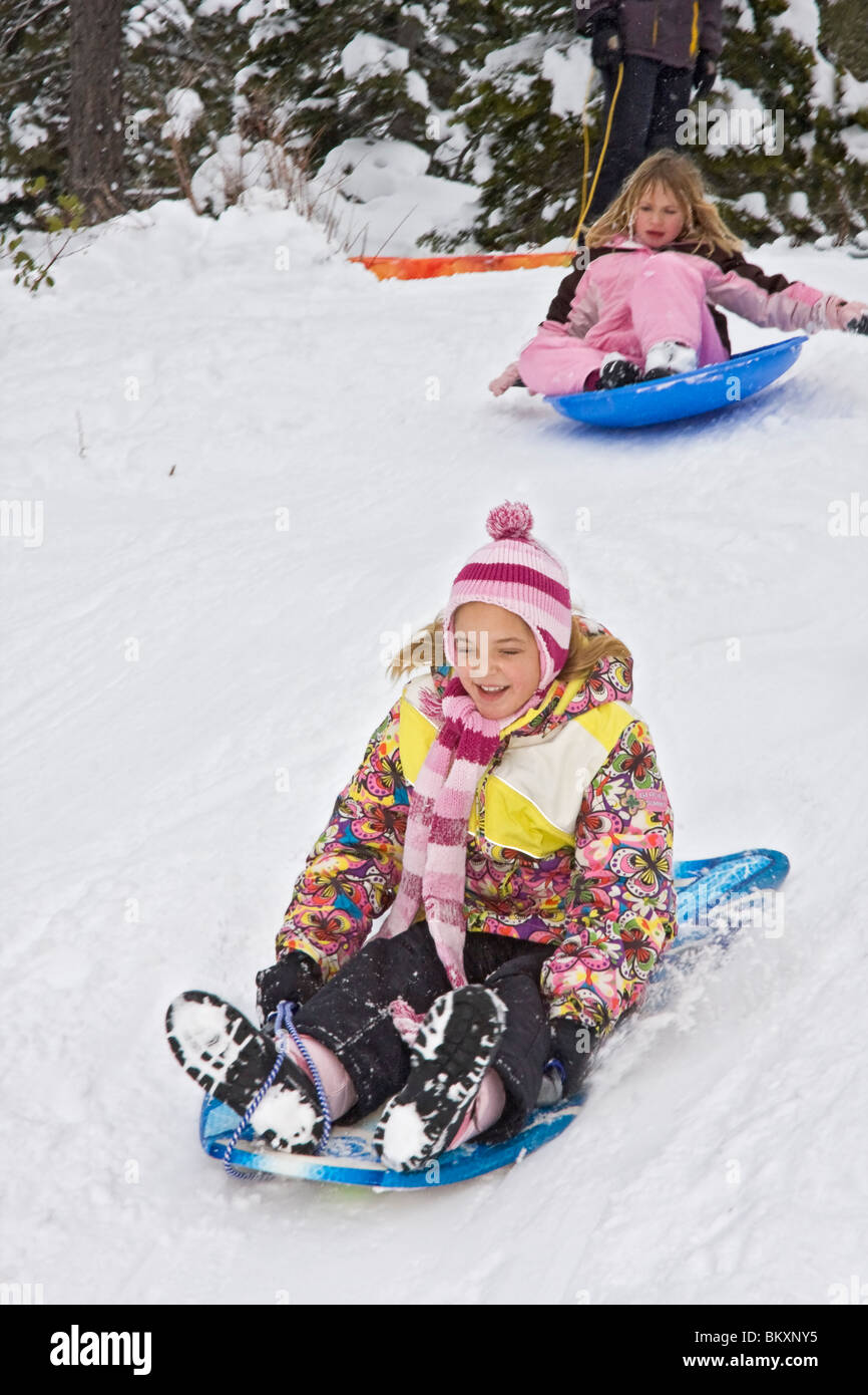 Children sled down short slope in winter, South Lake Tahoe, California ...
