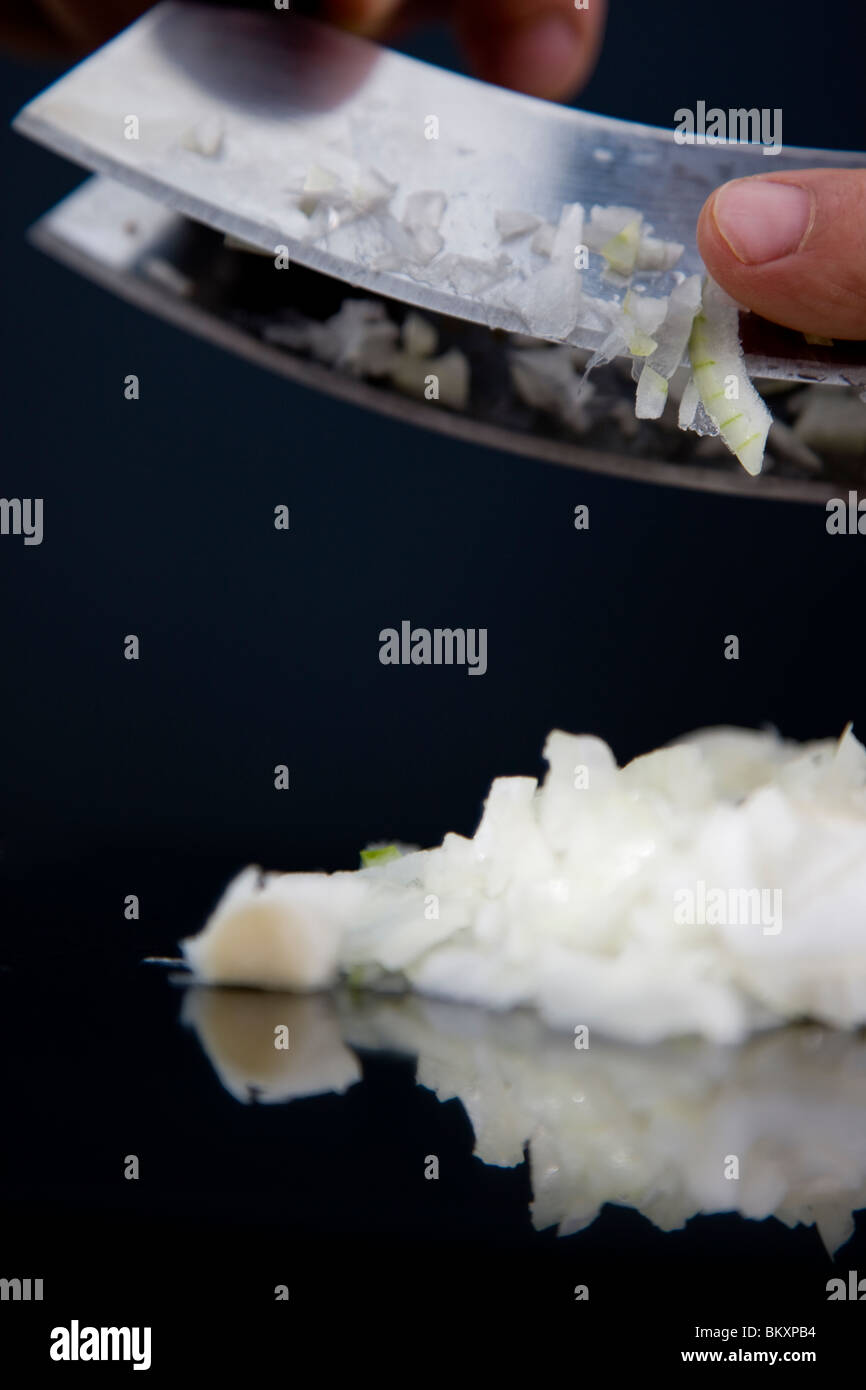 Close up of a chef hands chopping an onion with a double blade ...