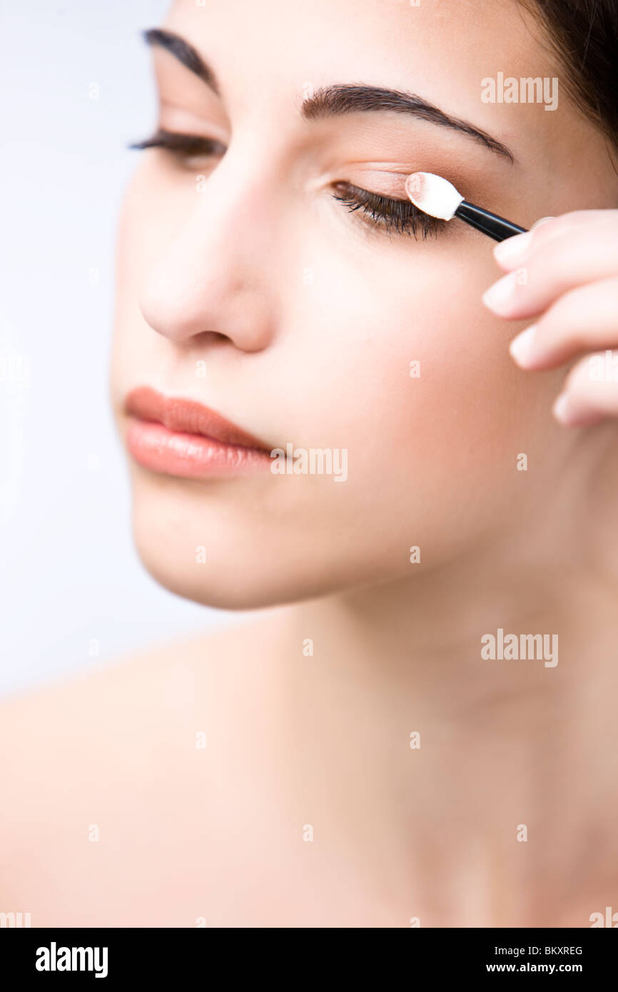 Profile up of a young woman applying eye shadow - close up Stock Photo ...