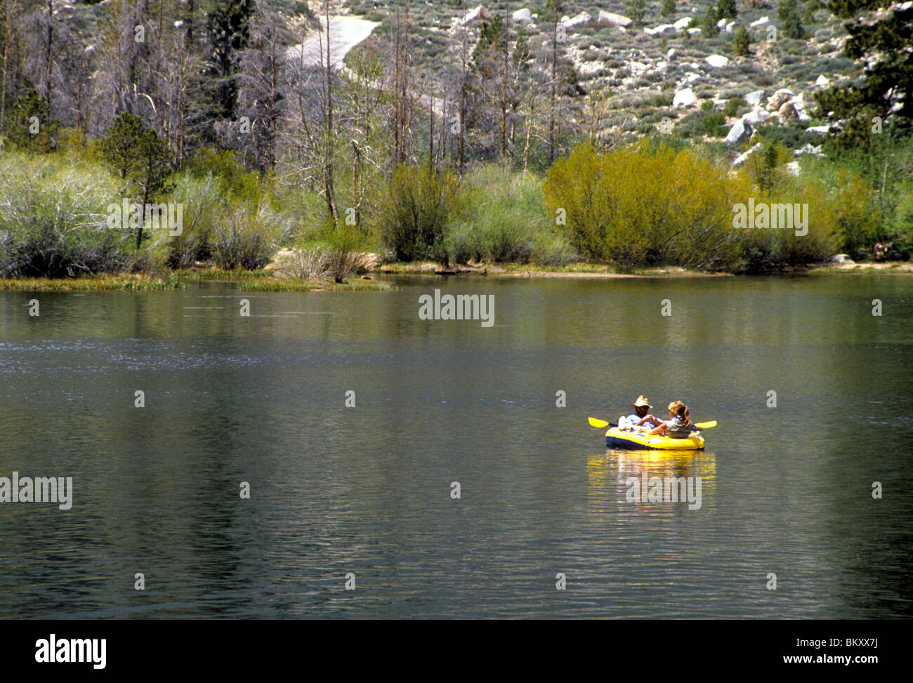 Couple ride in inflated rubber boat on Lake Intake Two in Sierra Nevada ...