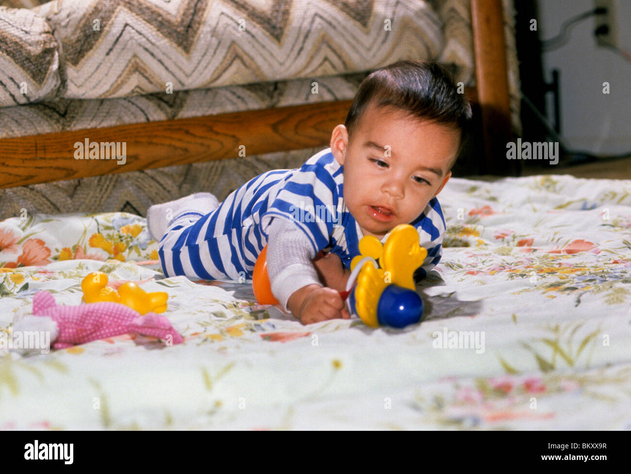 Hispanic baby boy play plastic rubber toy on floor of home house love ...