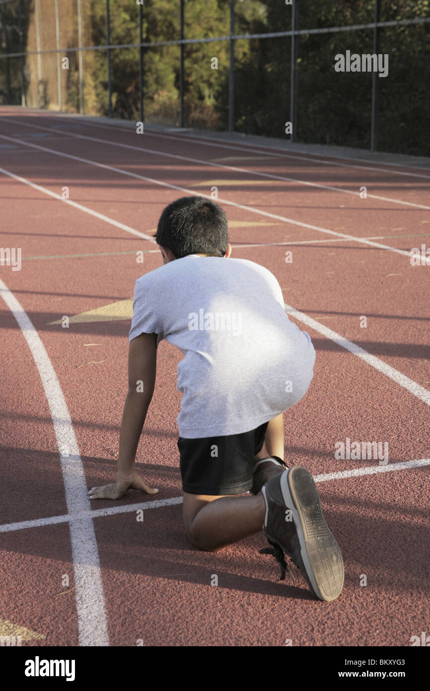 Boy in starting position on a running track Stock Photo - Alamy