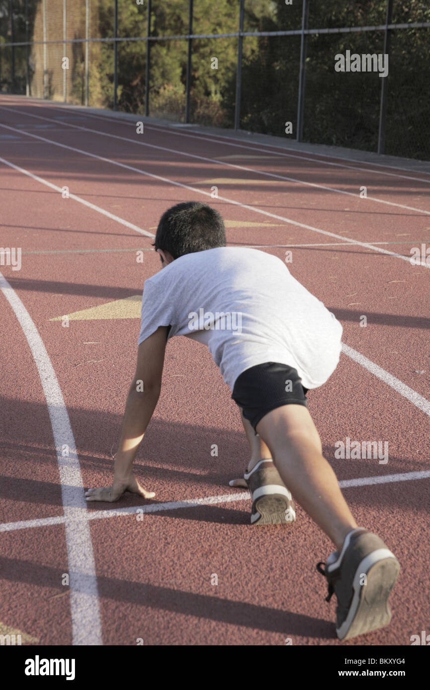 Boy in starting position on a running track Stock Photo - Alamy