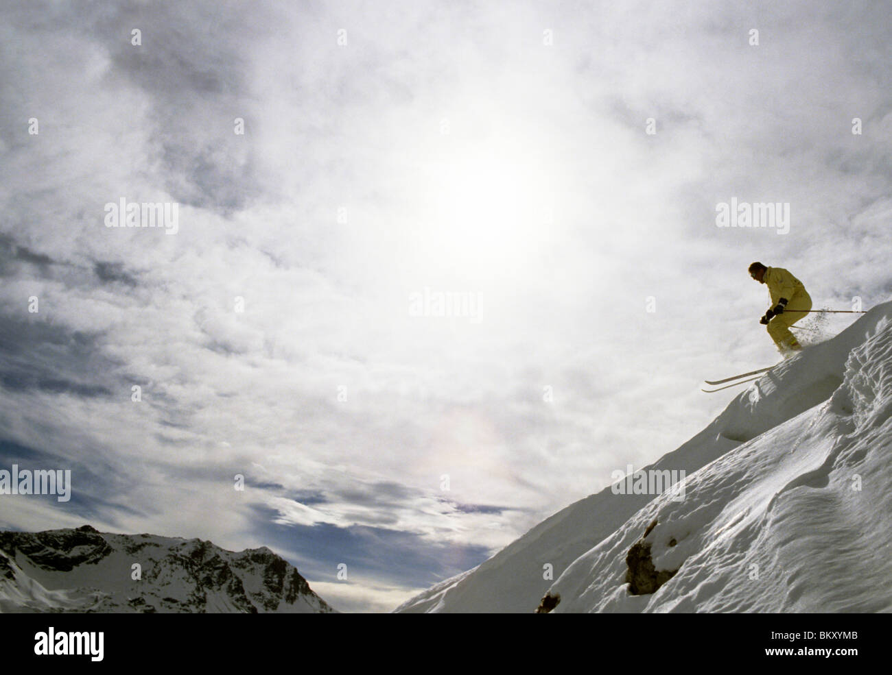 Man jumping off edge of slope while skiing Stock Photo - Alamy