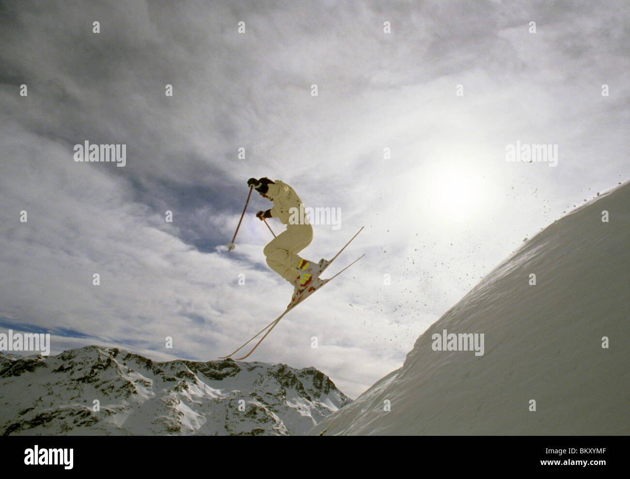 Man jumping off edge of slope while skiing Stock Photo - Alamy
