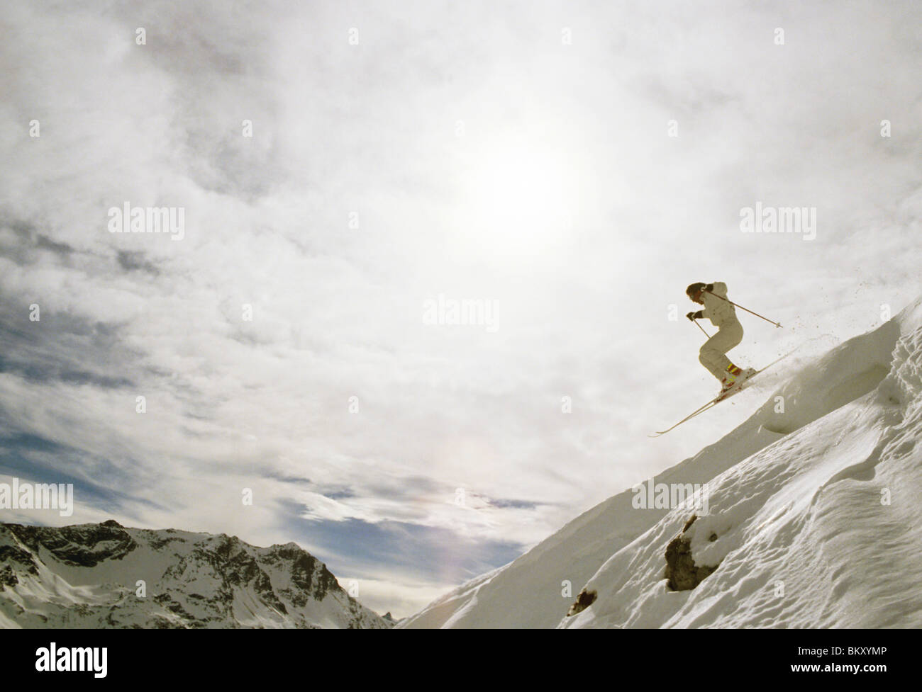 Man jumping off edge of slope while skiing Stock Photo - Alamy