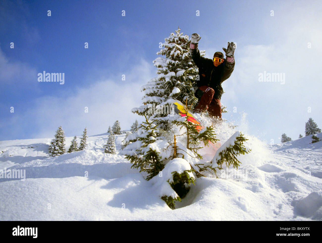 Man jumping over moguls while snowboarding Stock Photo - Alamy