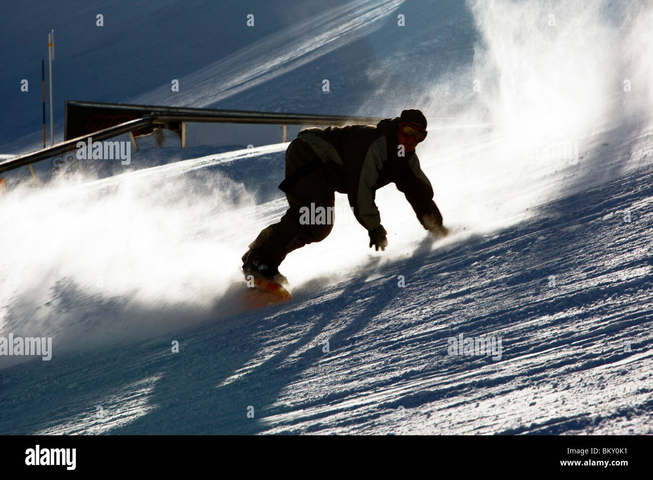 Man snowboarding down slope keeping balance and touching ground Stock ...