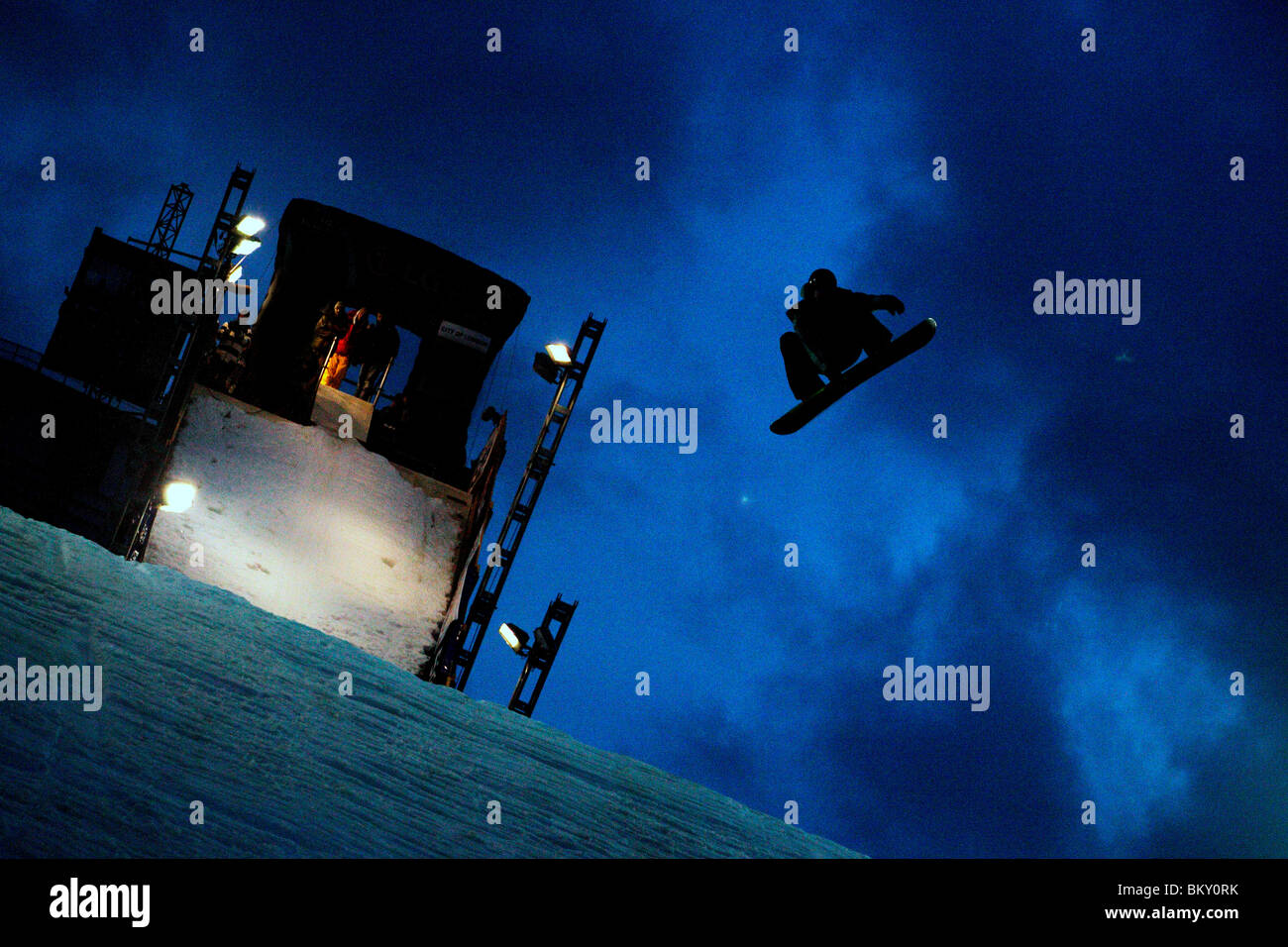 Person jumping while snowboarding at nighttime Stock Photo - Alamy