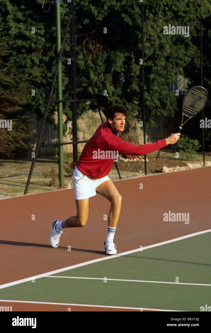 Man hitting return ball in tennis match Stock Photo - Alamy