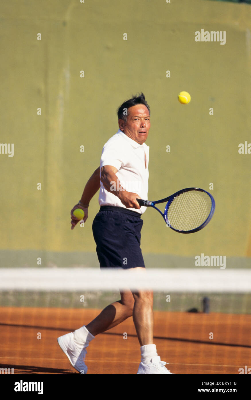 Man swinging backhand in tennis match Stock Photo - Alamy