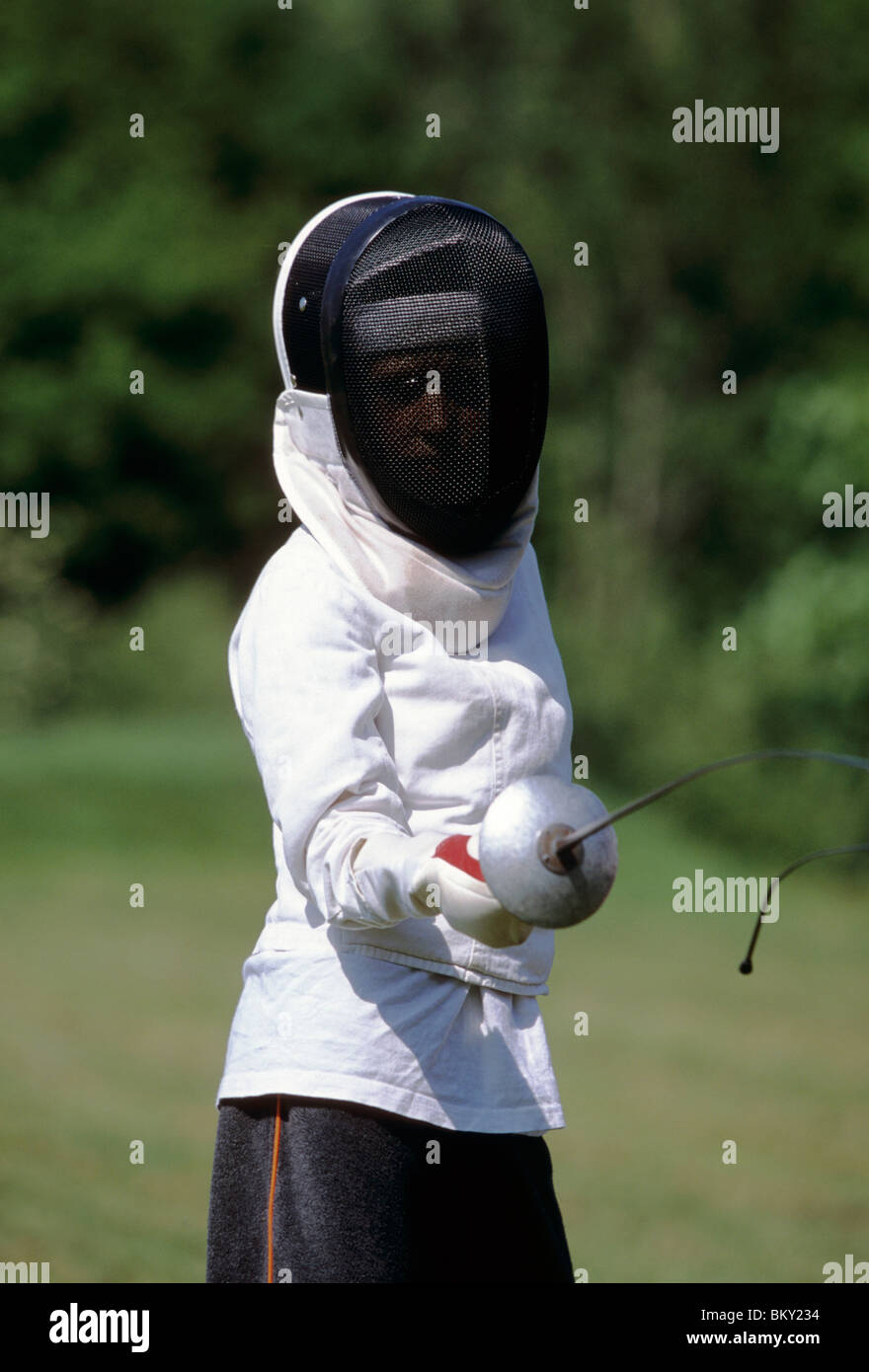 Boy with fencing sword in hand wearing face mask and uniform Stock ...