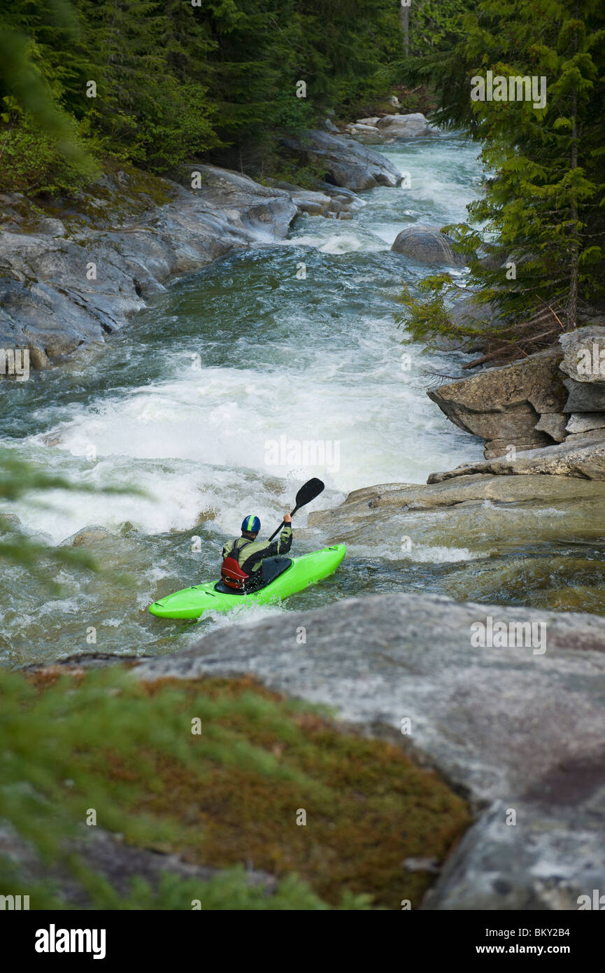 A whitewater kayaker sets up for a drop on a high mountain river Stock ...