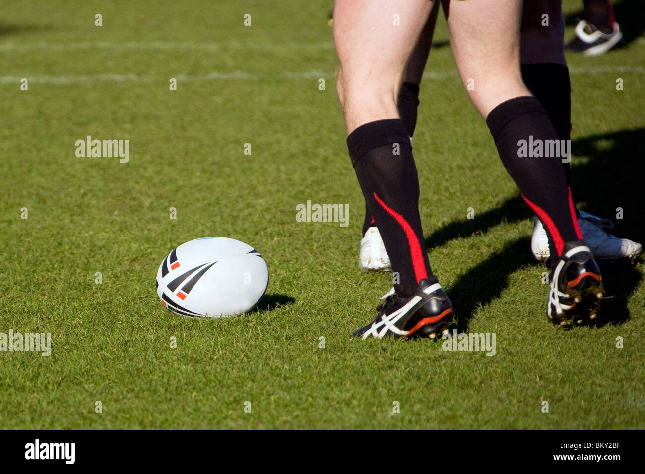 Two men standing above rugby ball Stock Photo - Alamy
