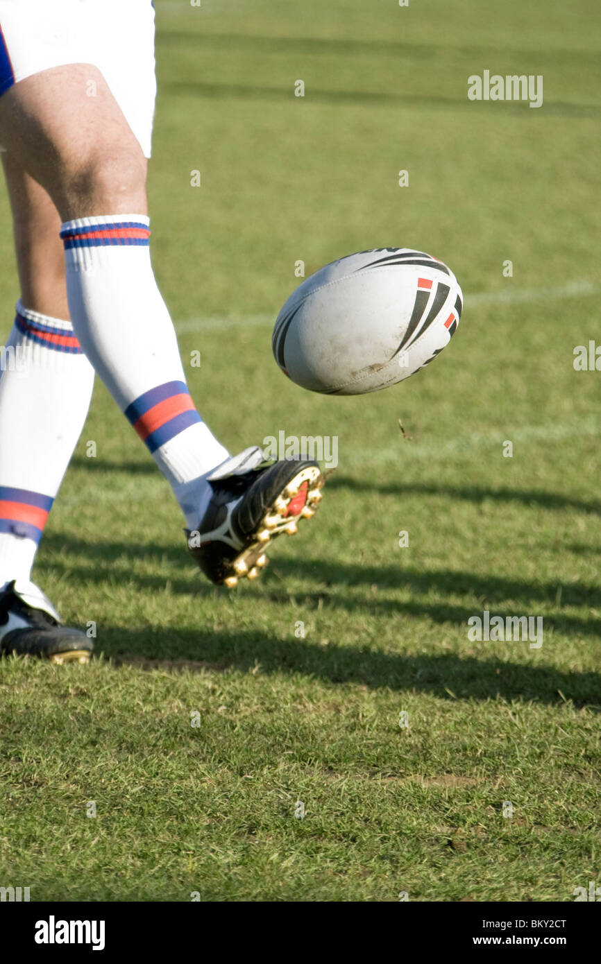 Rugby player kicks ball forward Stock Photo - Alamy